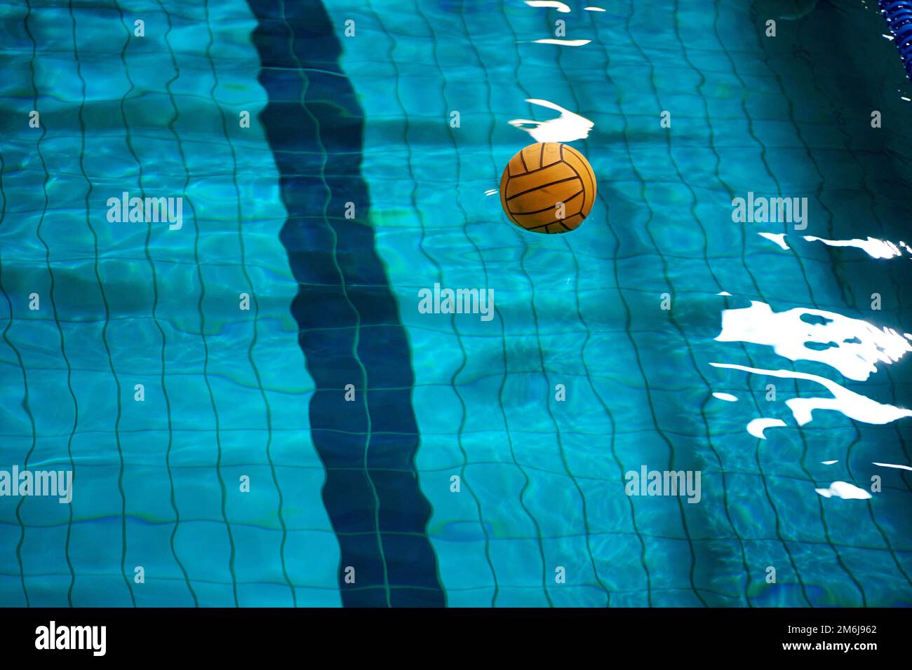 Water polo. Yellow water polo ball in a swimming pool on blue water ...