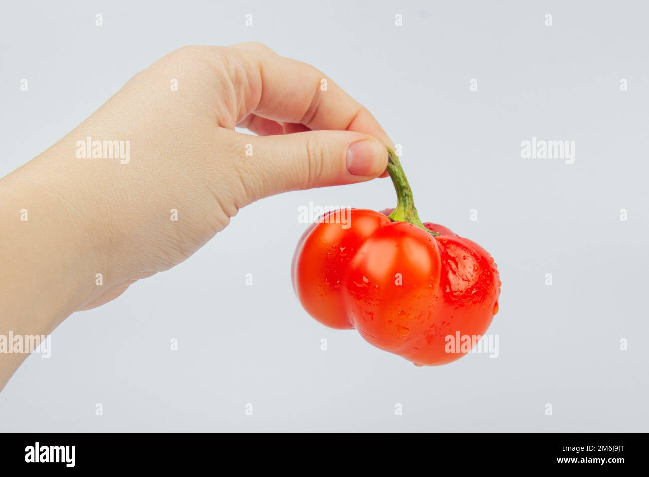 Red, green and yellow peppers in the store. Female hands pick and take ...