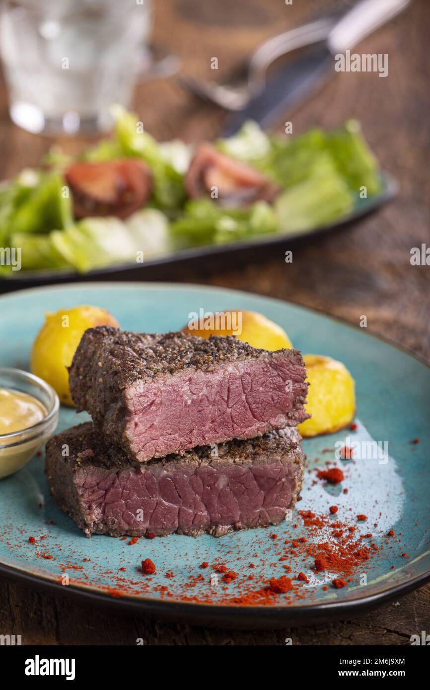 Steak slices on a blue plate Stock Photo - Alamy