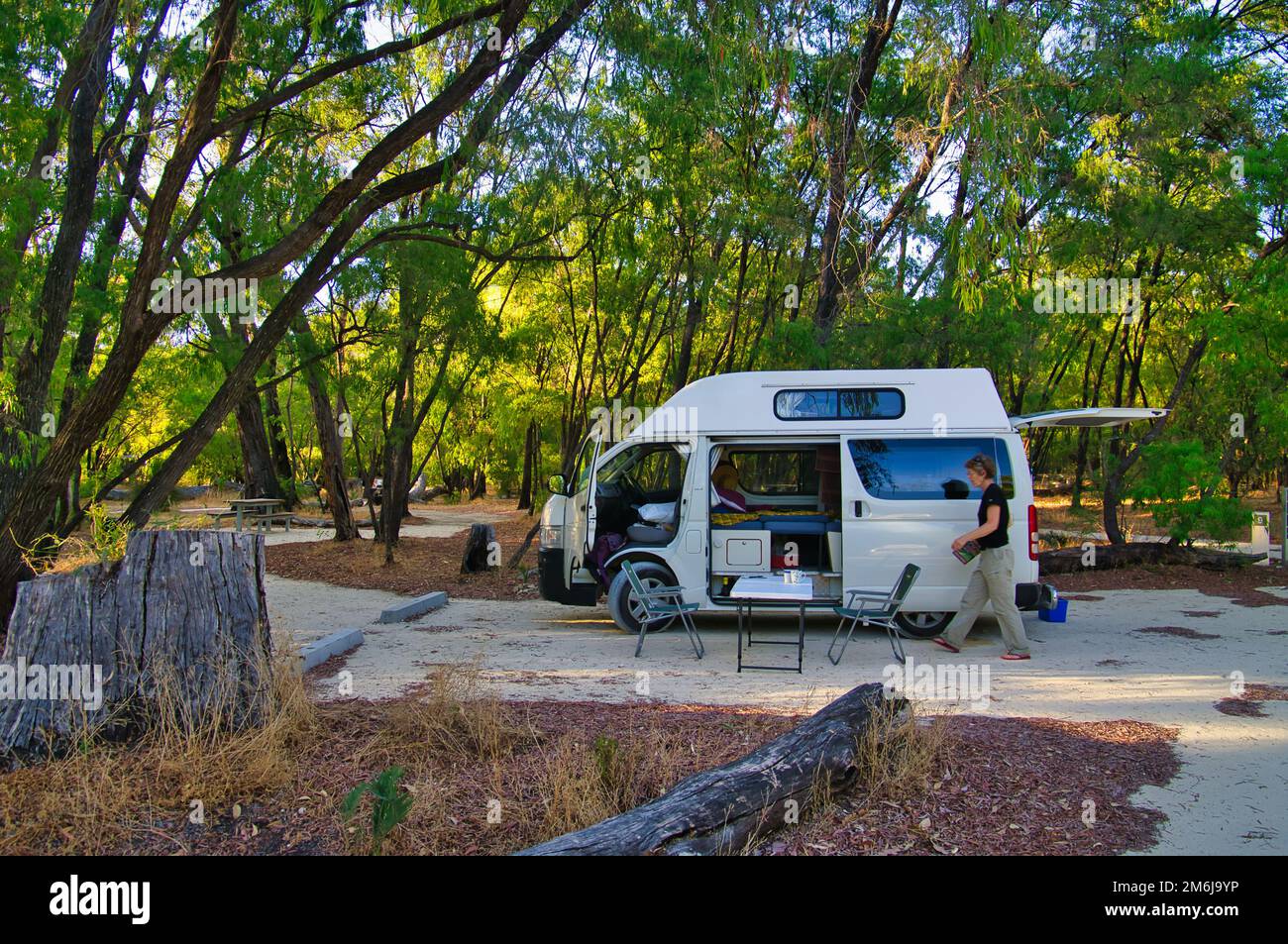 Small rv with open doors and a woman setting the table on a National ...