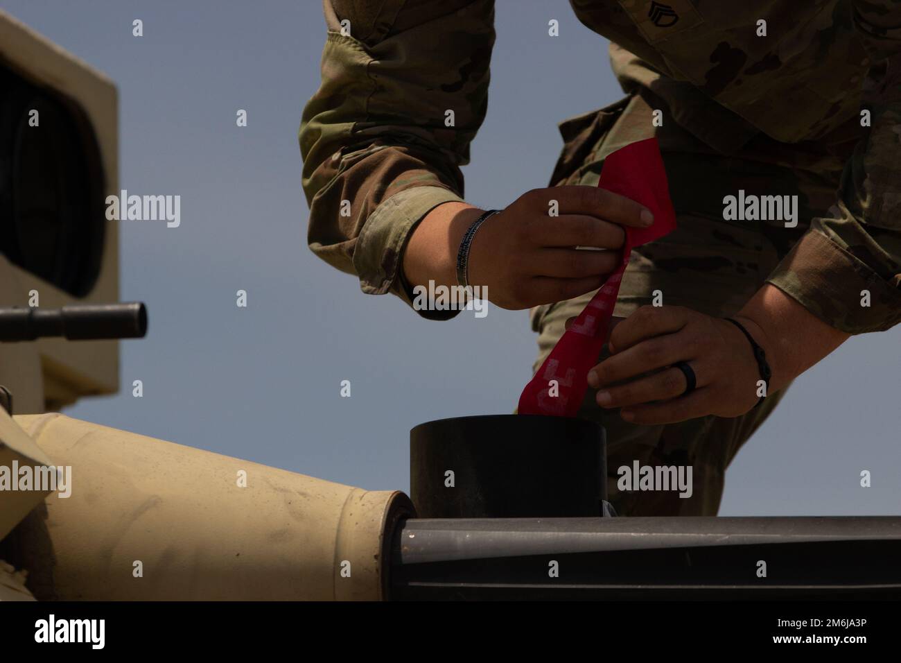 A U.S. Army soldier takes a remove-before-firing tag out of a canister ...