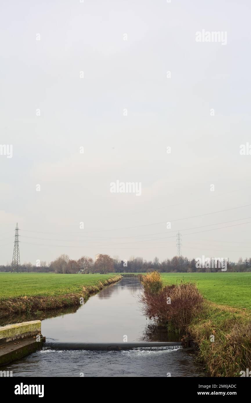 Stream of water between cultivated fields on an overcast day in the ...