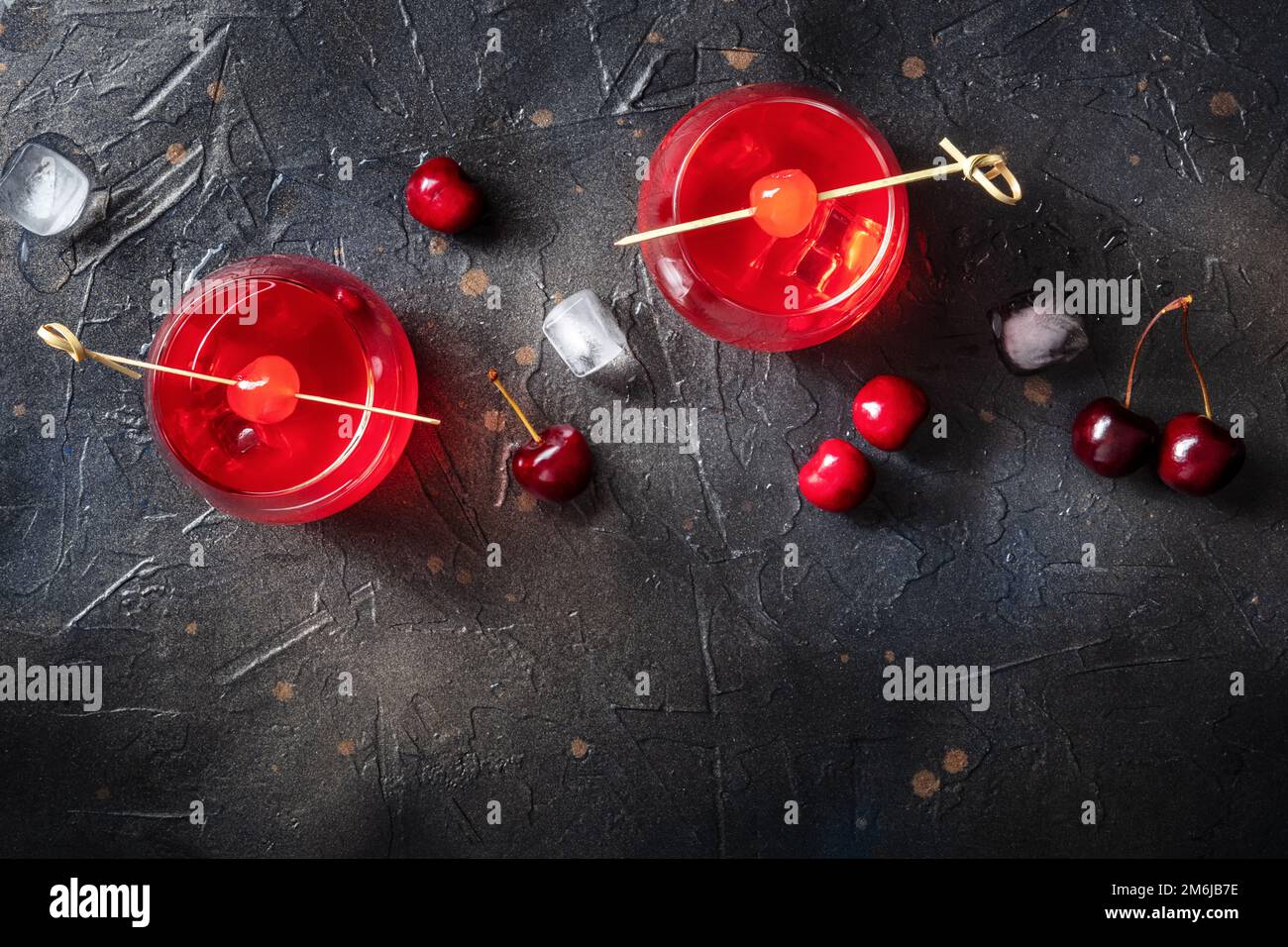 Cocktail cherry and a mocktail on a dark background, a vibrant red ...