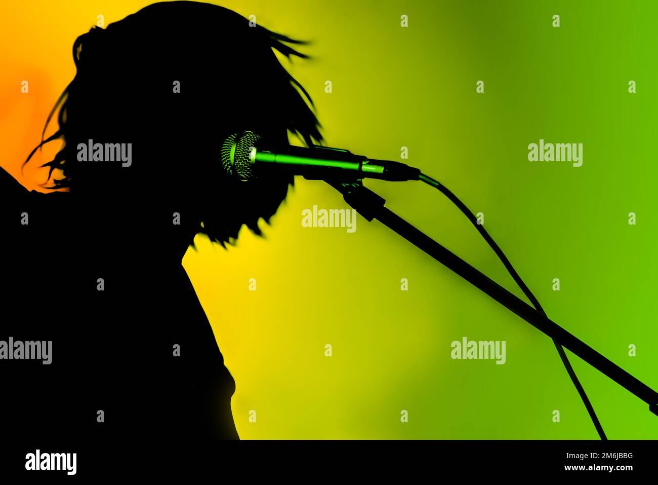 Silhouette of a male singer performing microphone in focus Stock Photo ...