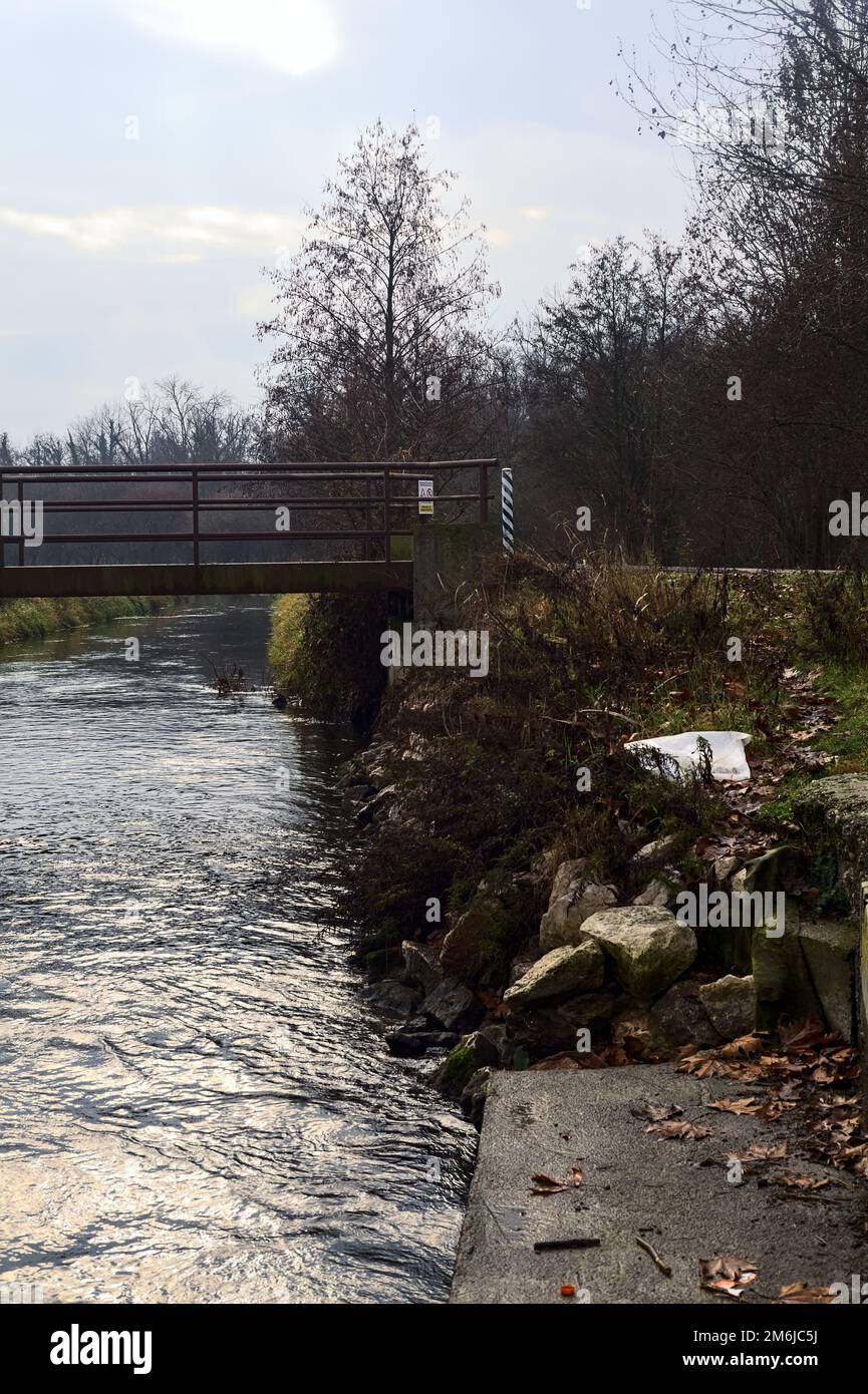 Bridge over a stream of water in the italian countryside in winter ...