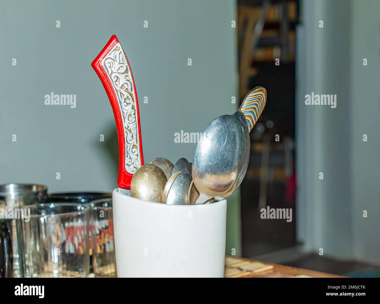 White container full of spoons, forks and knives on a table in a ...
