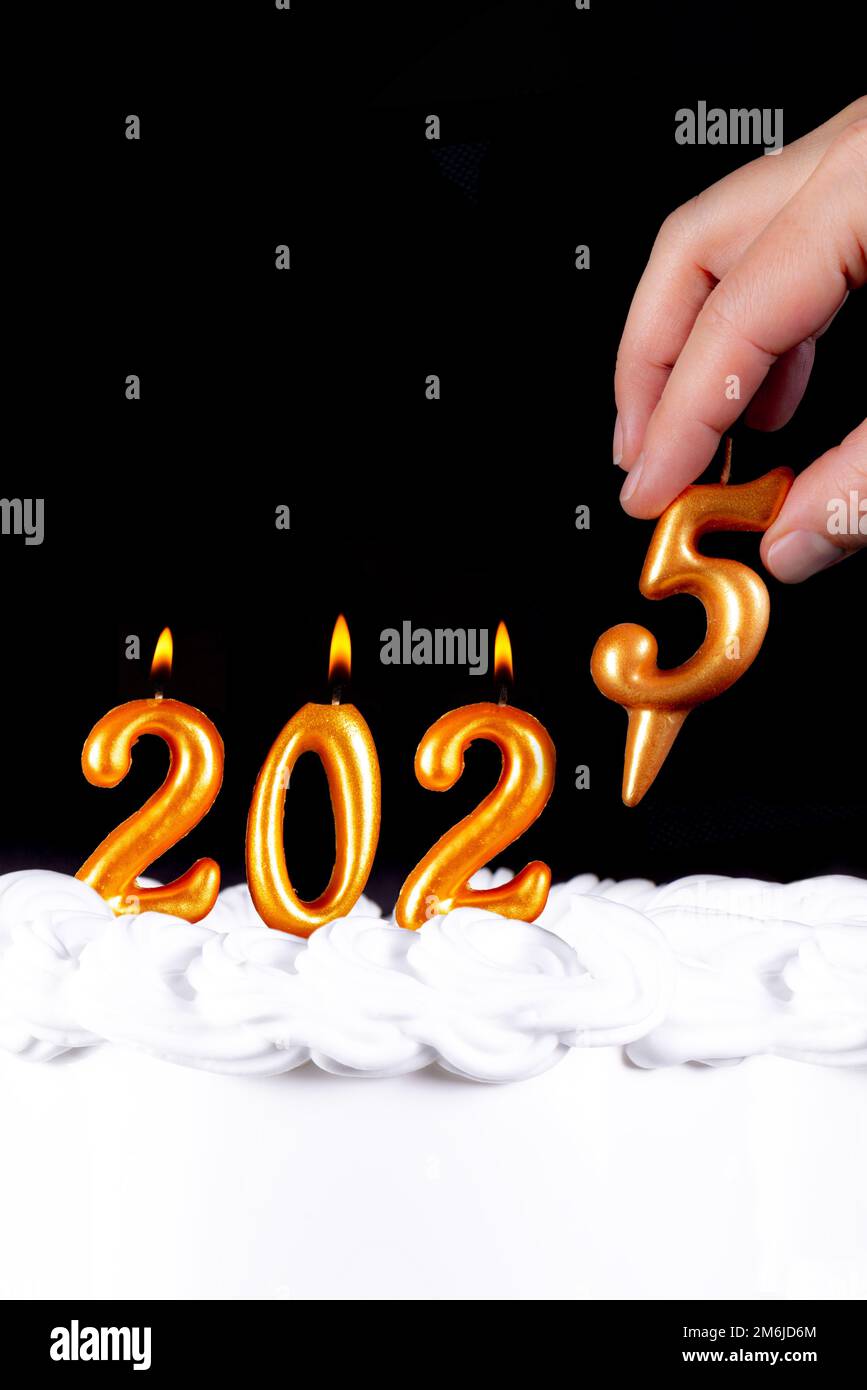 Golden candles write numbers flame Happy new year 2025 hand Stock Photo ...