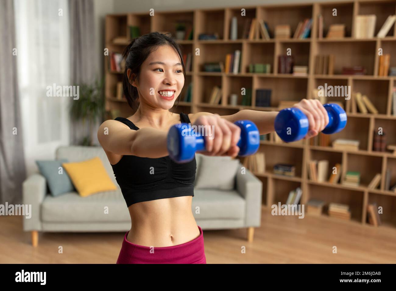 Joyful young japanese lady doing domestic training, working out with ...