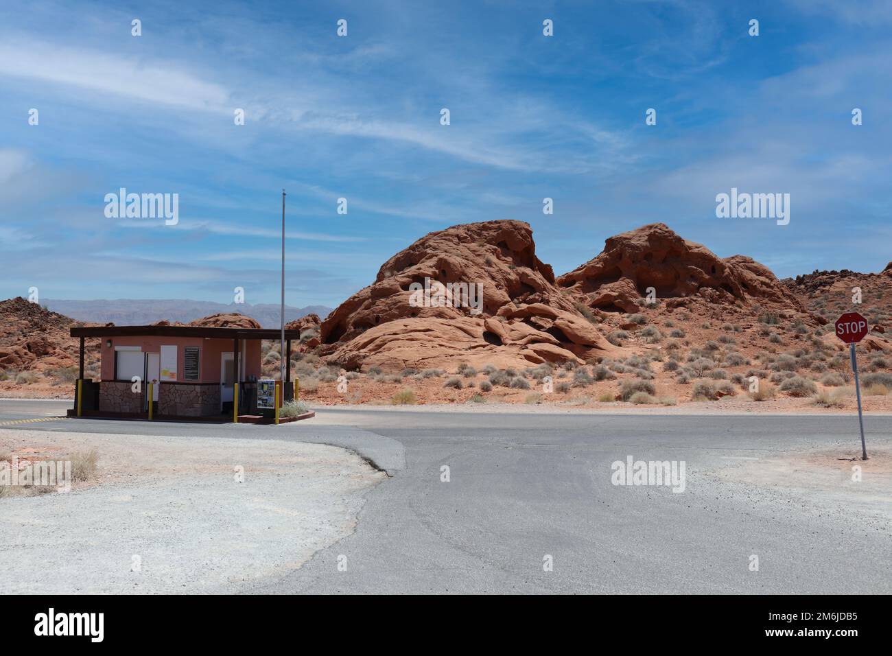 Bright red Aztec sandstone rock formations, along the road, lined with ...