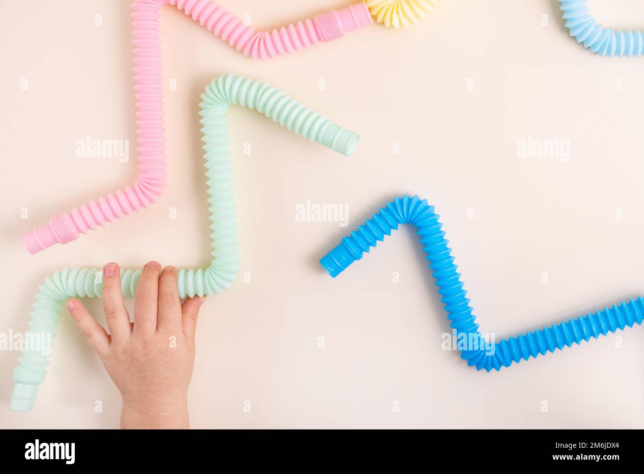 Trendy kids toys pastel colorful pop-tube in baby toddler hands on ...
