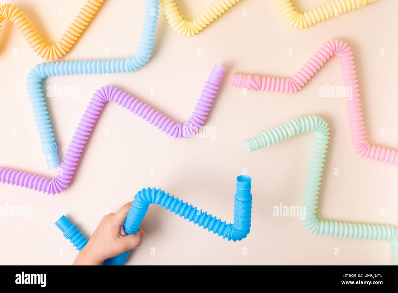 Trendy kids toys pastel colorful pop-tube in baby toddler hands on ...