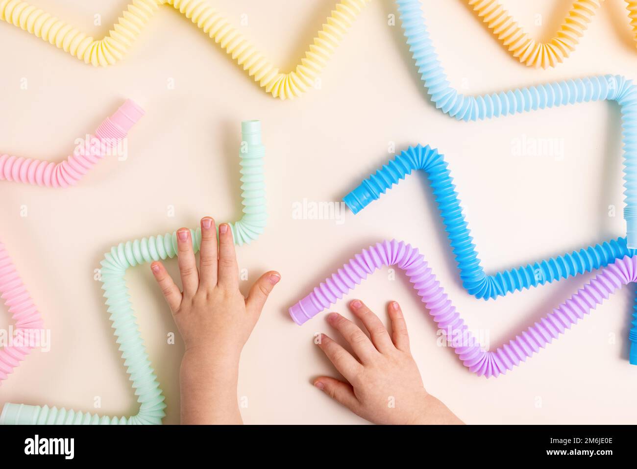 Trendy kids toys pastel colorful pop-tube in baby toddler hands on ...