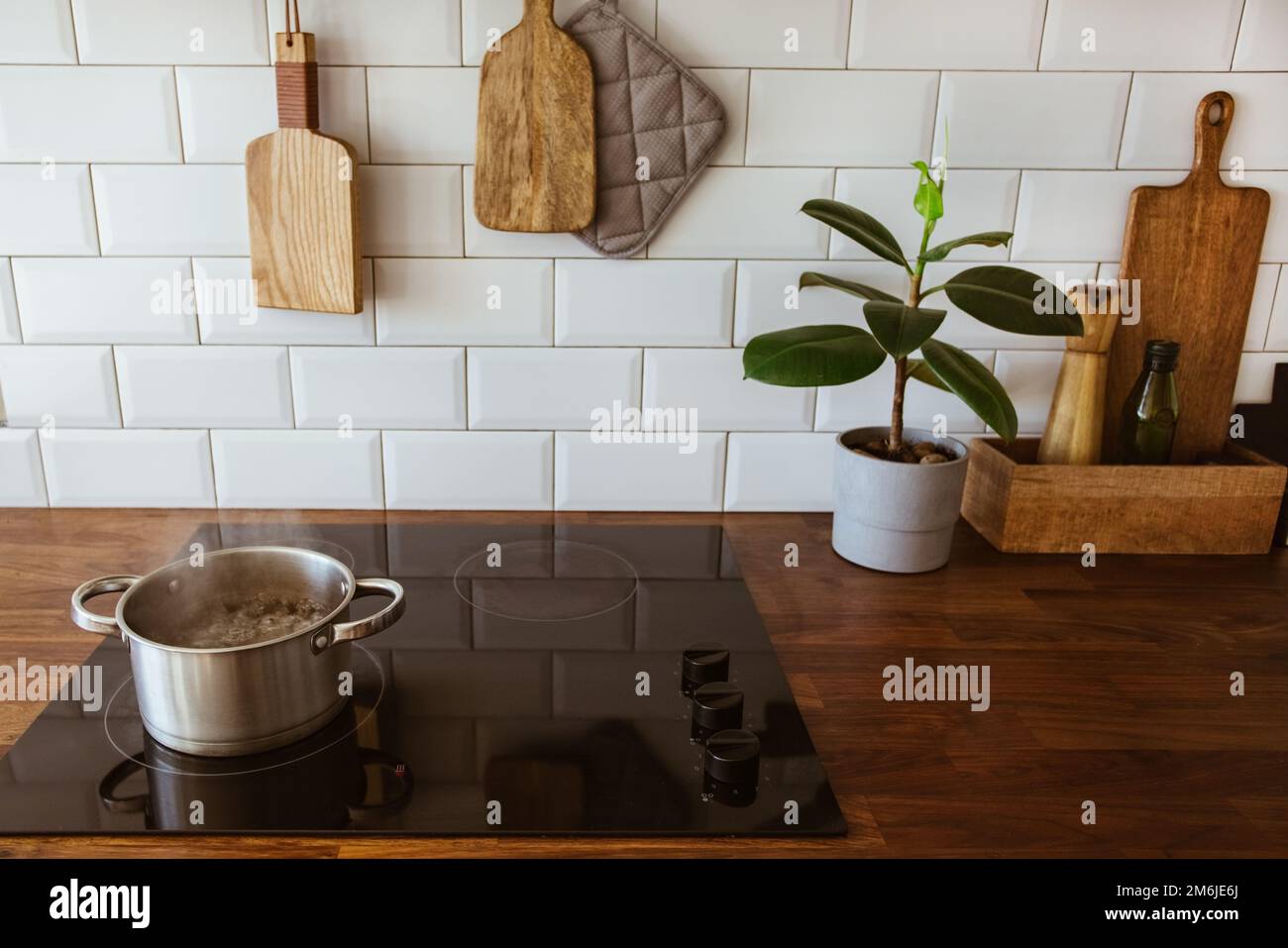 Boiling water in a cooking pot an a pan on a induction stove in the ...