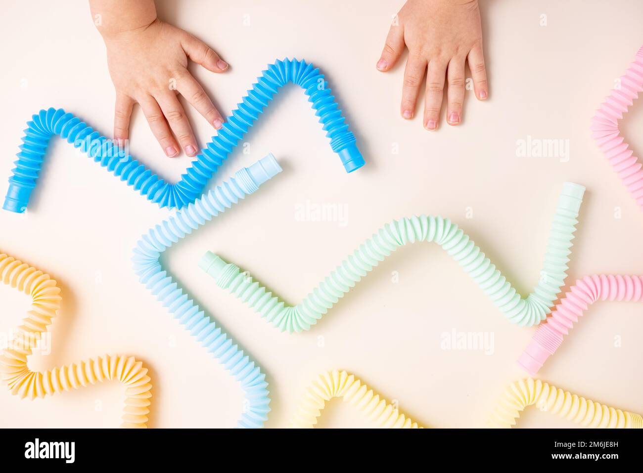 Trendy kids toys pastel colorful pop-tube in baby toddler hands on ...