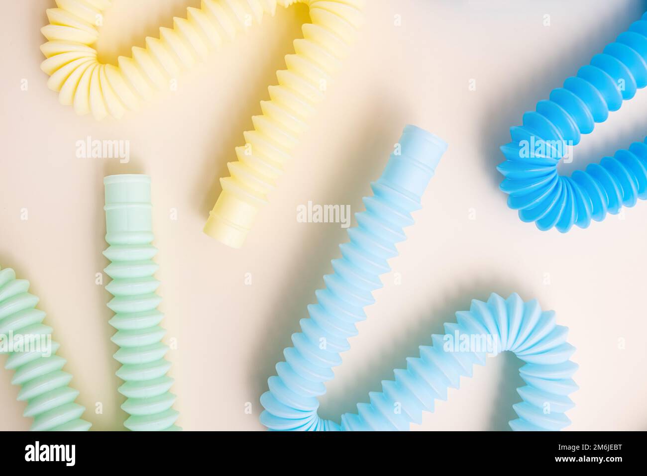 Trendy kids toys pastel colorful pop-tube on beige background. Set of ...