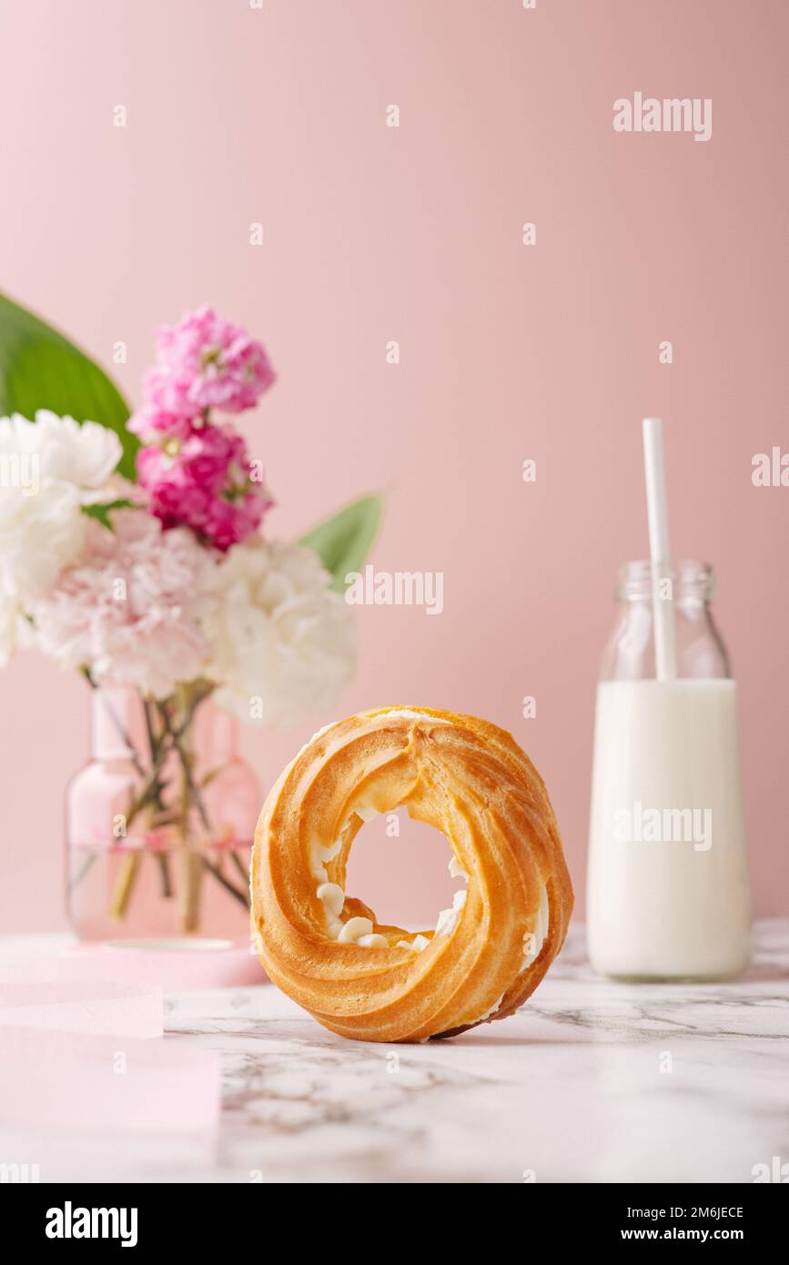 Homemade circle profiterole with custard covered sugar powder on marble ...