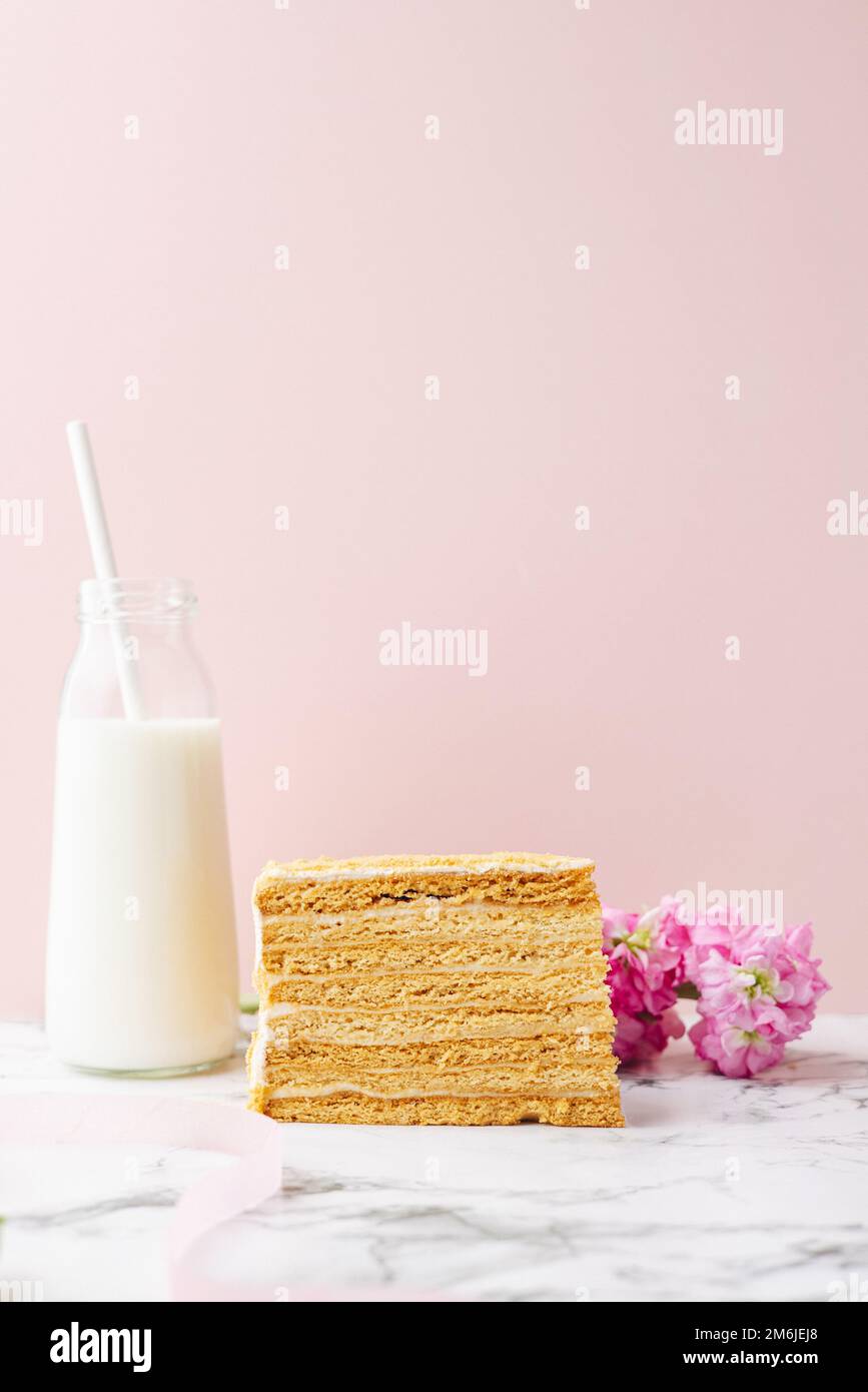 Traditional Russian cake Medovik, honey cake with bottle of milk and ...