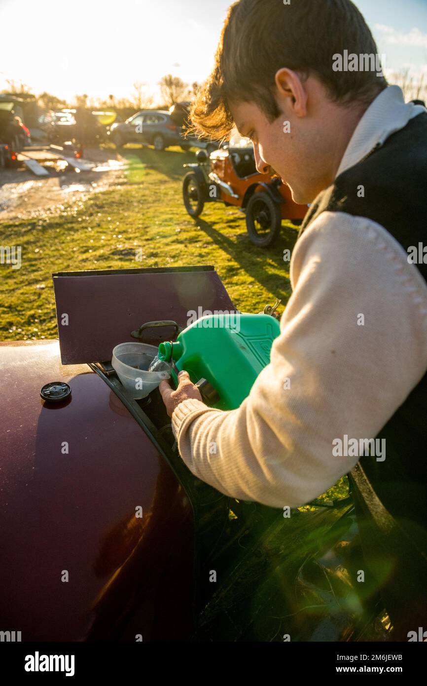 The Pre War Austin 7 car club member preparing his car and filling the ...