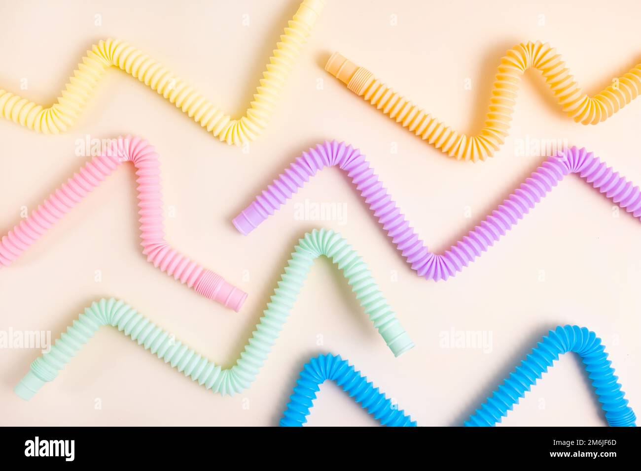 Trendy kids toys pastel colorful pop-tube in baby toddler hands on ...