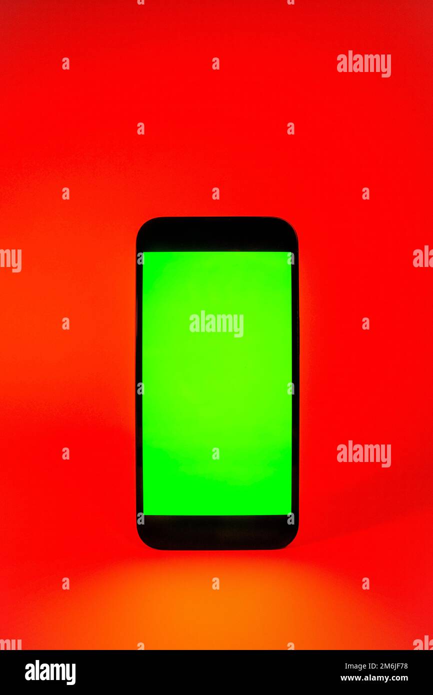 Mobile phone with green screen, smartphone mock up. Red illumination ...