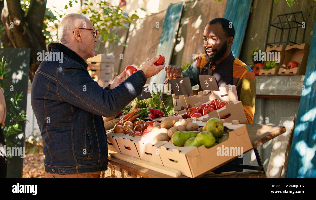 Group of diverse people talking about farmers market products on stand ...
