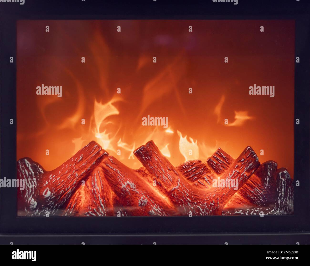 The logs of the fireplace burn with a bright fire. Artificial ...