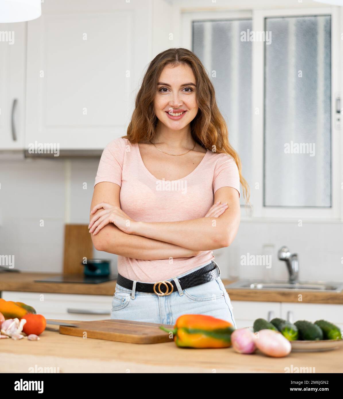 Girl standing in cozy kitchen interior at home, slicing fresh ...