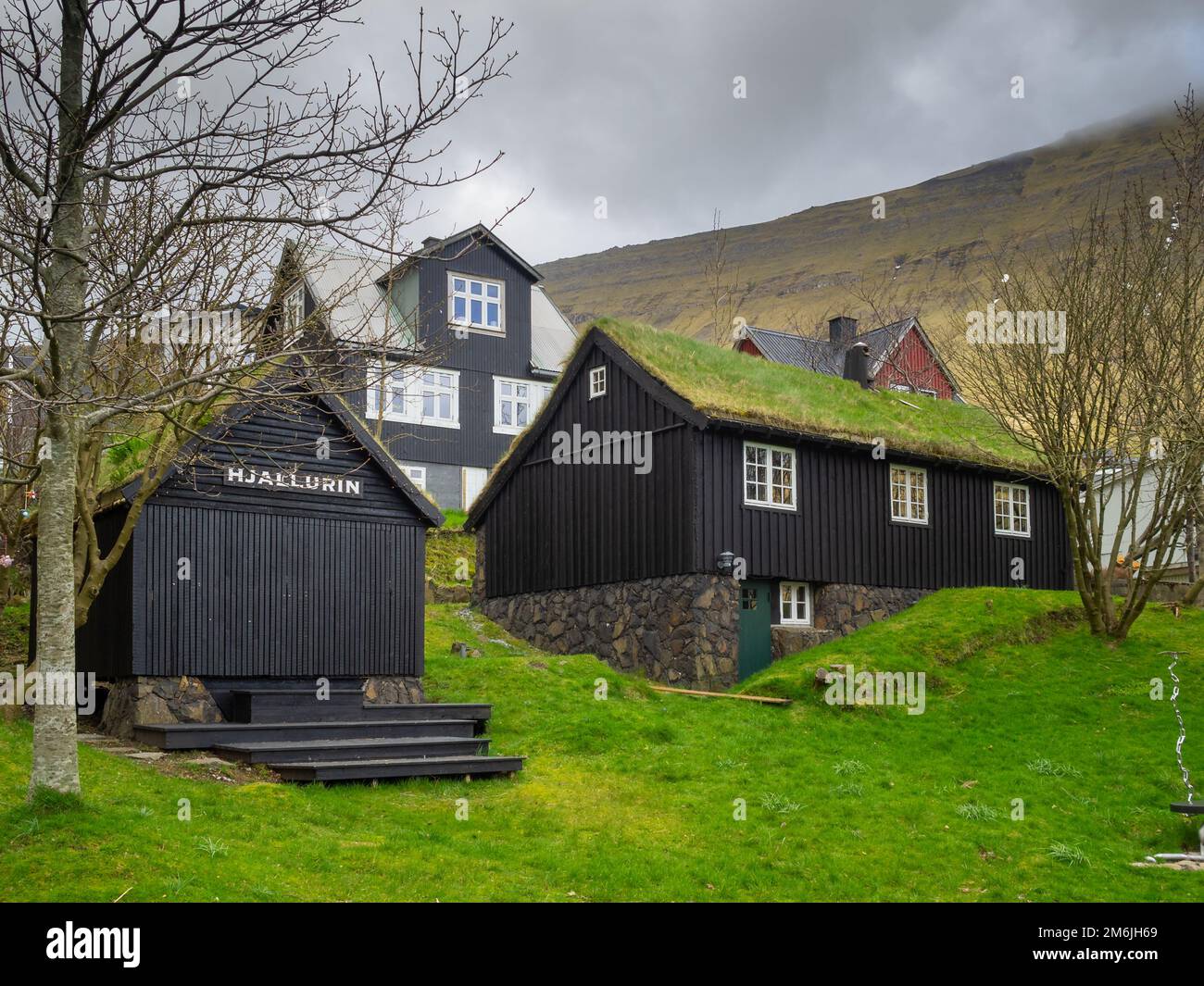 Traditional houses with black tared timber walls and turf roof in ...