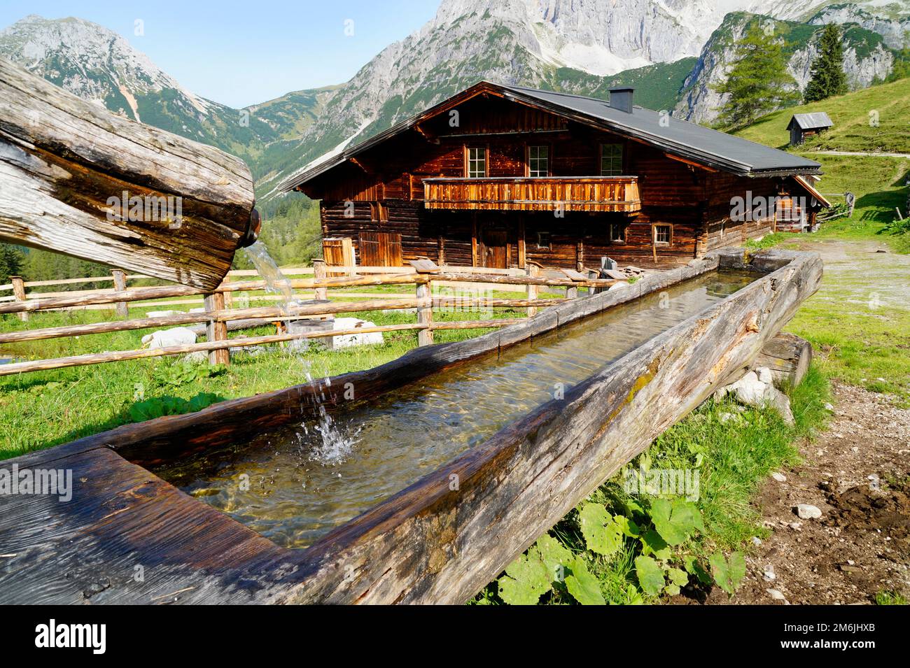 alpine cabin and a water trough by the foot of the Dachstein mountain ...