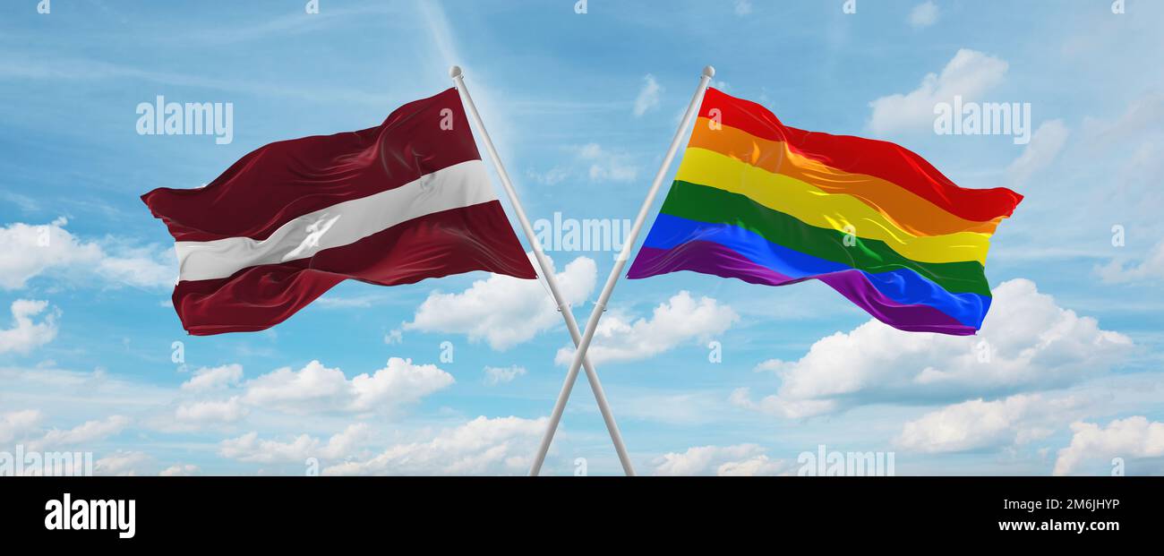 two crossed flags LGBT Pride and Latvia waving in wind at cloudy sky ...