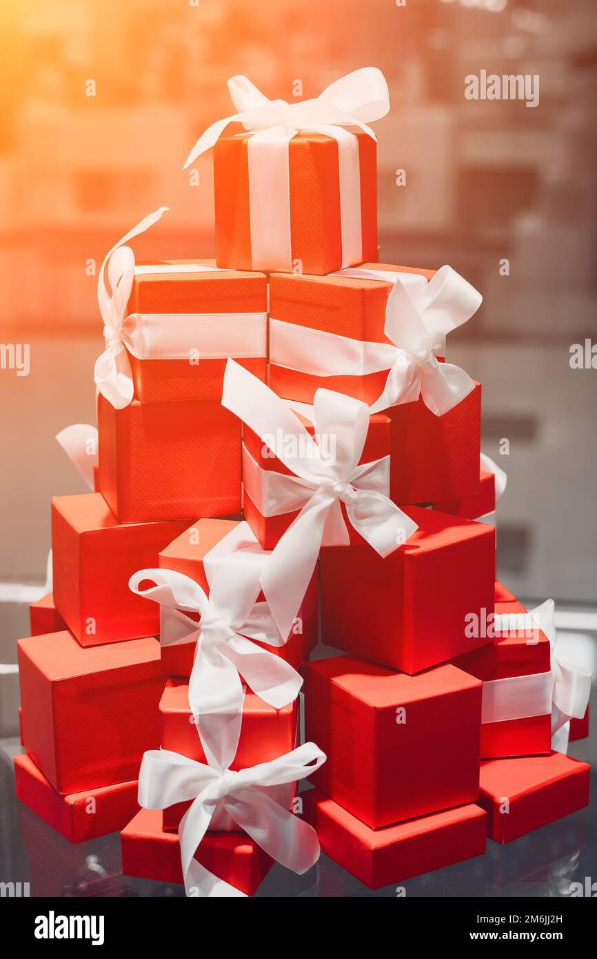 Festive composition of bright red boxes with white bows. A gift for the ...