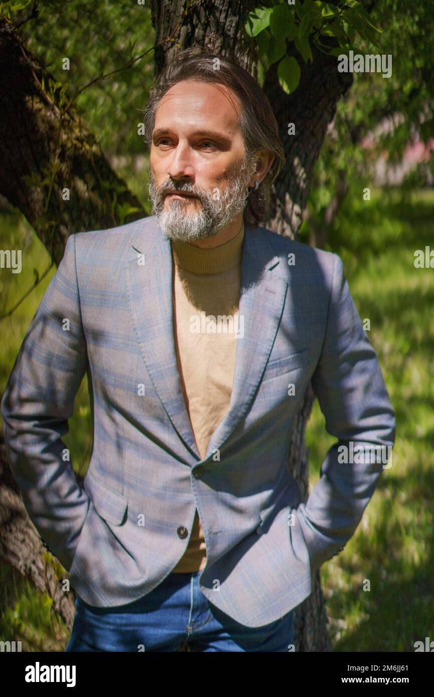 Mature handsome man in 40s 50s in park or yard, away of business or ...