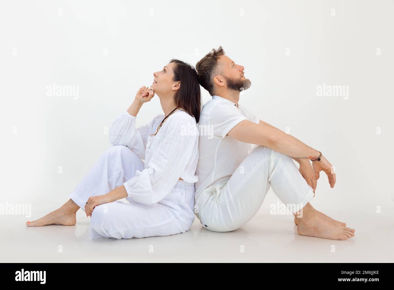 Happy sporty family of young woman and middle-aged man, sitting back-to ...