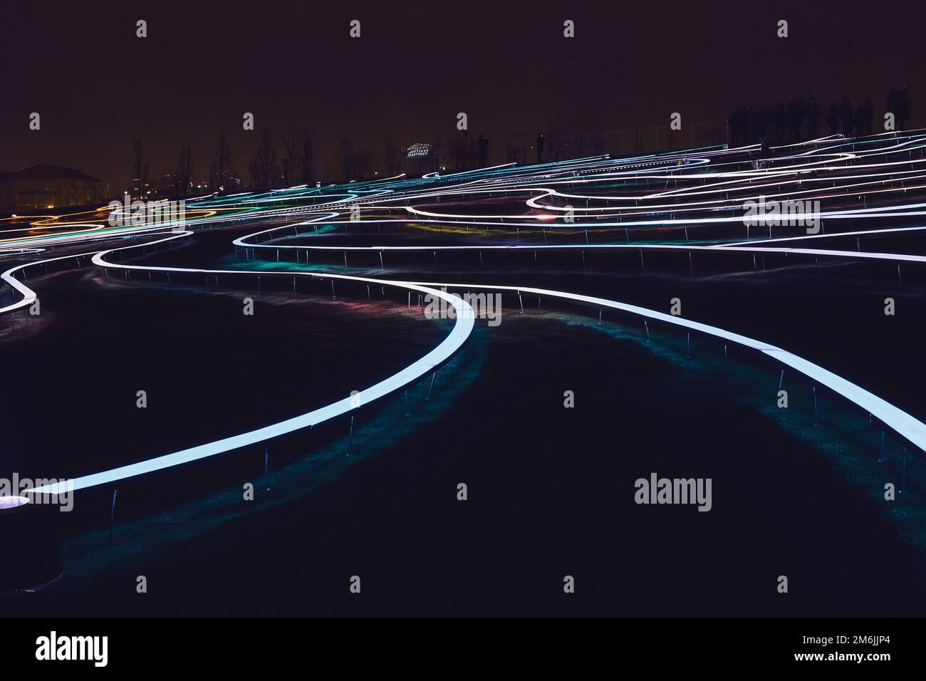 Large walking park area with luminous winding lines at night. Unusual ...