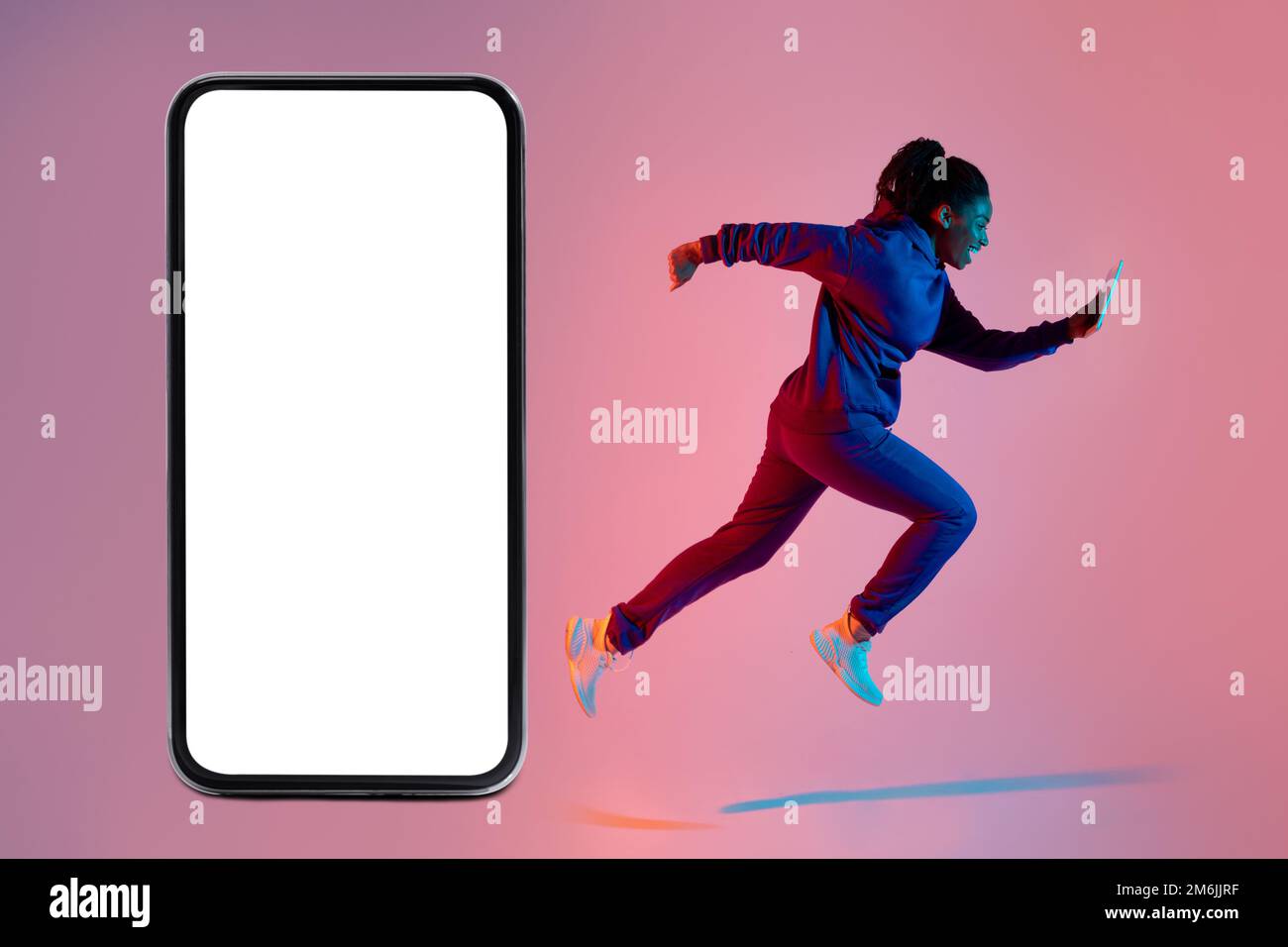 Active black lady exercising, running with cellphone next to giant ...