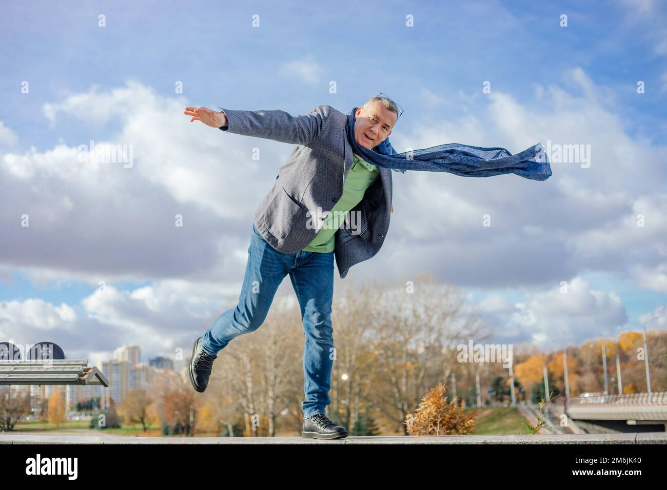 Portrait of cute middle-aged man balancing standing on one leg on ...