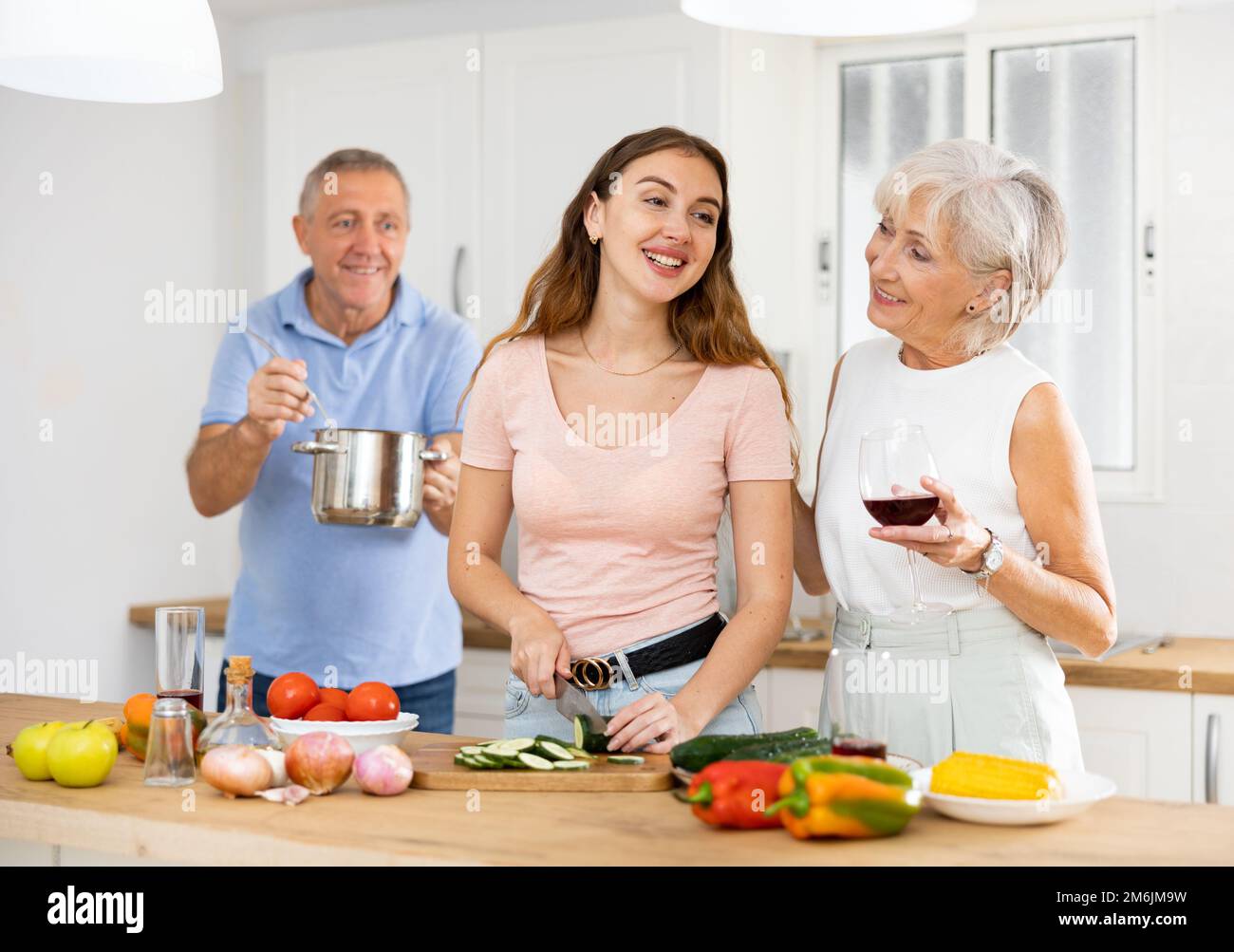 Happy family of three preparing lunch together in modern kitchen Stock ...