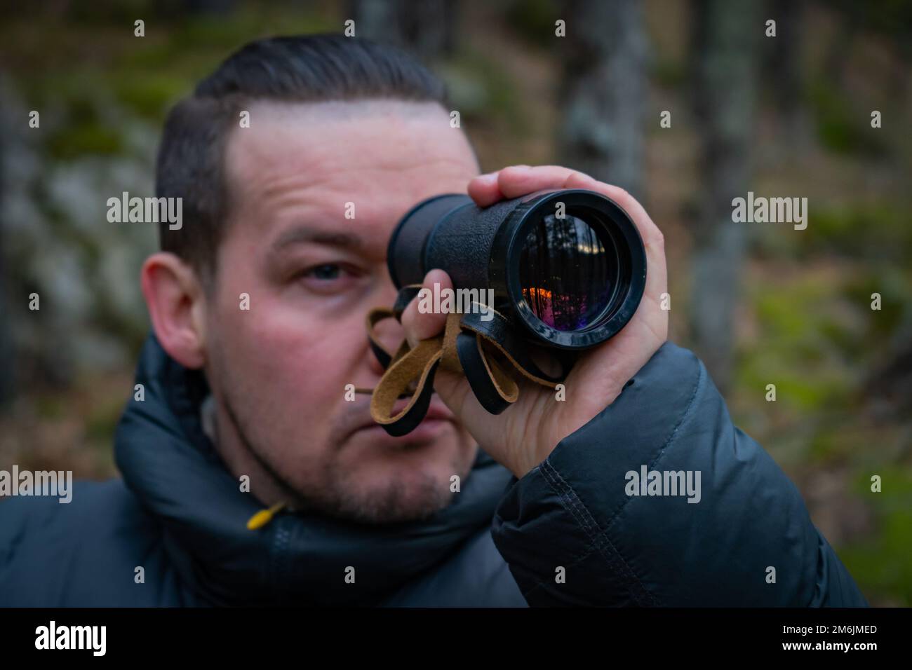 Traveler with monocle sitting on big stone in deep forest and looks ...