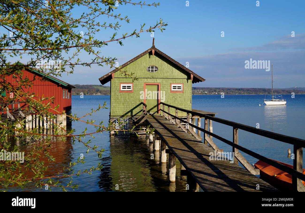 a long wooden pier leading to the colorful boat houses on lake Ammersee ...