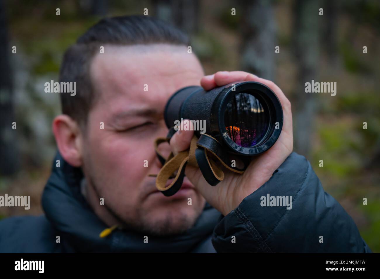 Traveler with monocle sitting on big stone in deep forest and looks ...