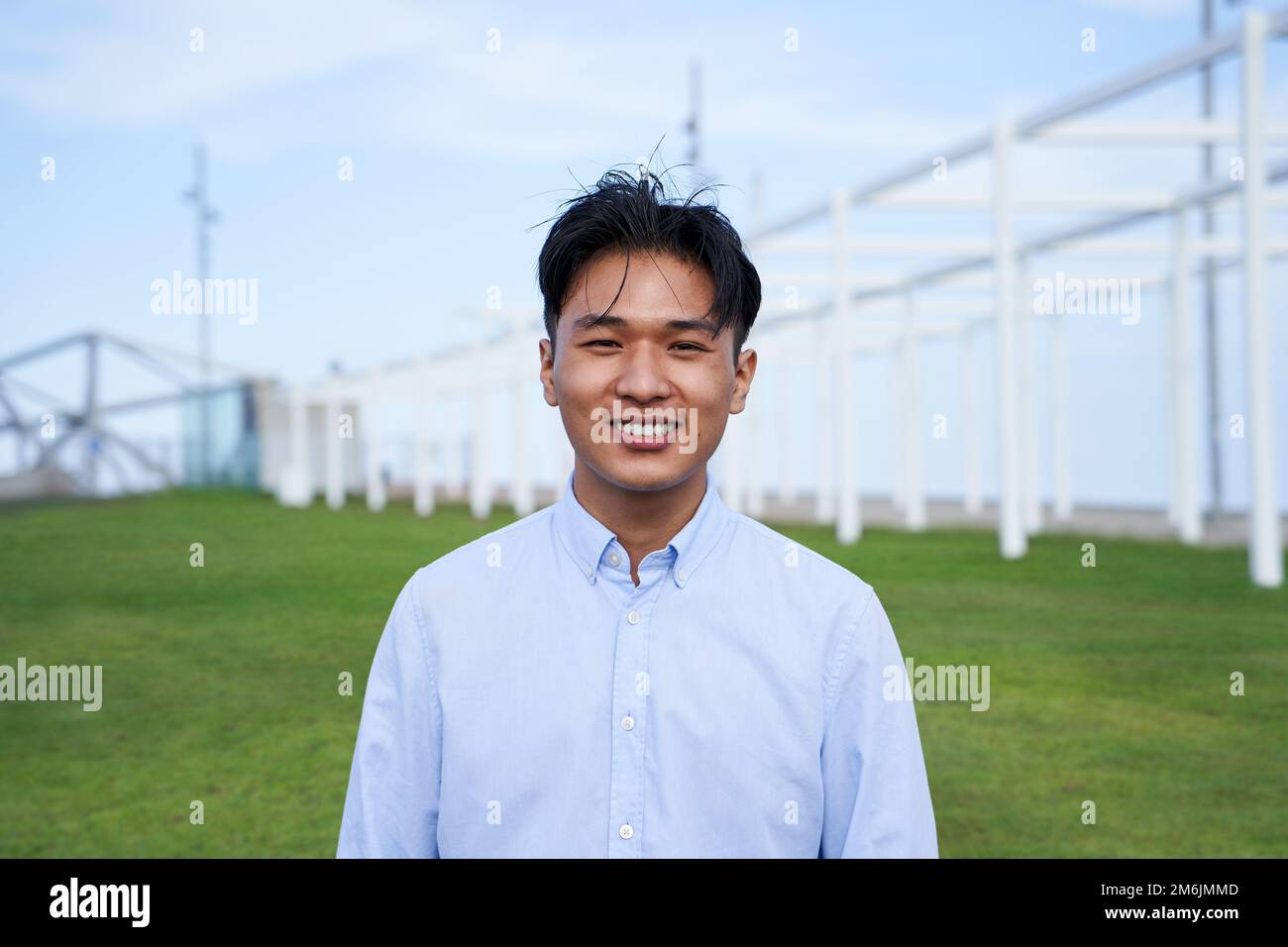 Looking at the camera portrait of an Asian guy Smiling young standing ...