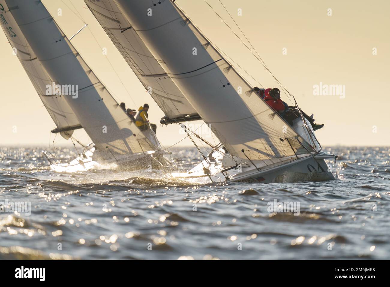 Teamwork in sailing regatta at sunset, still water, the clear sky, hot ...