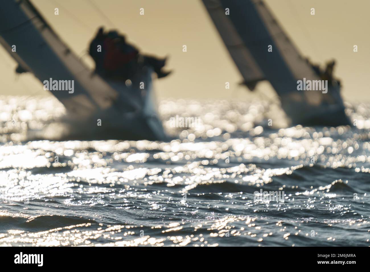 Teamwork in sailing regatta at sunset, still water, the clear sky, hot ...