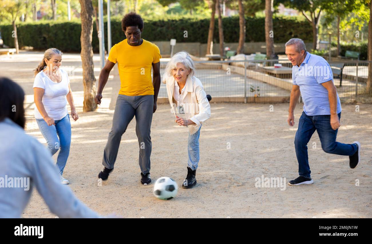 Cheerful group of mixed-race middle-aged and older adult people playing ...