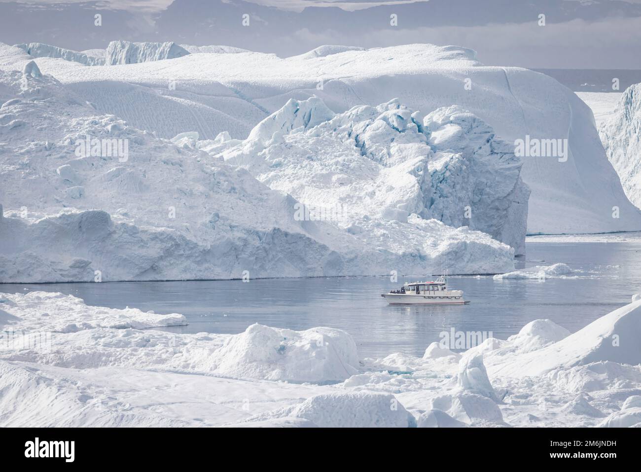 small ship sailing between white icebergs Stock Photo - Alamy