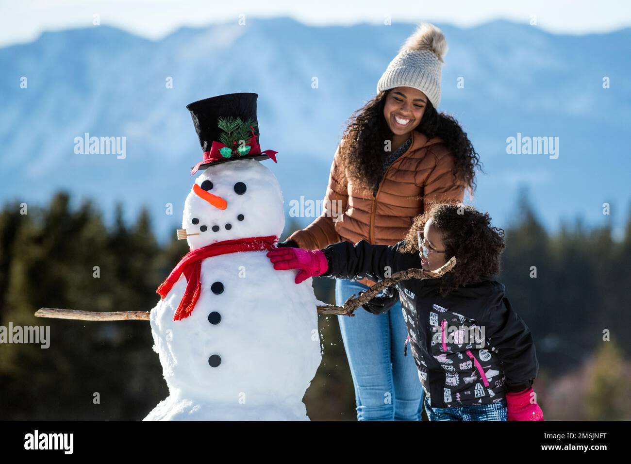 Two girls building a snowman in Stateline, Nevada Stock Photo - Alamy