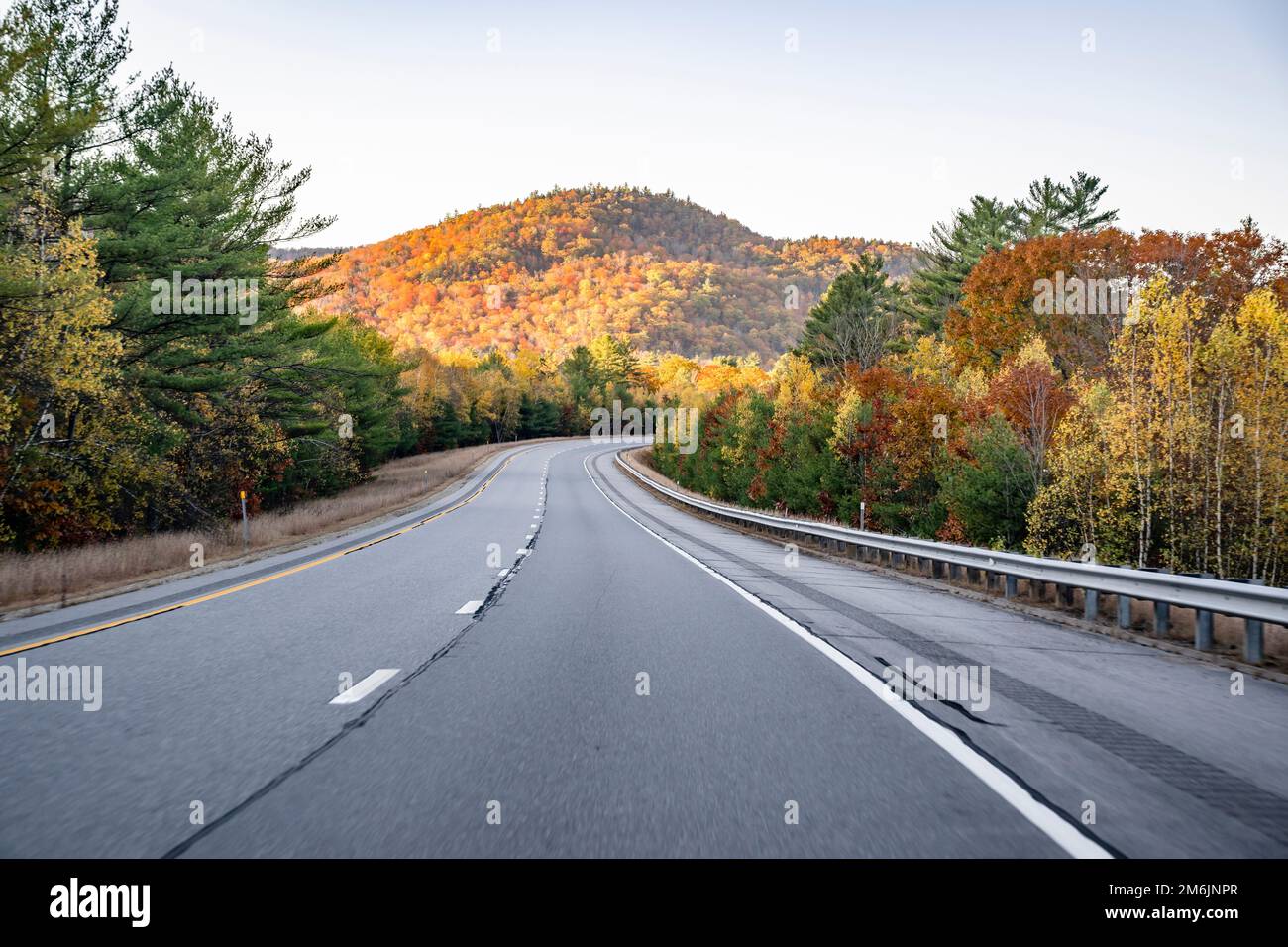 Scenic autumn landscape with a disappearing at horizon winding highway ...