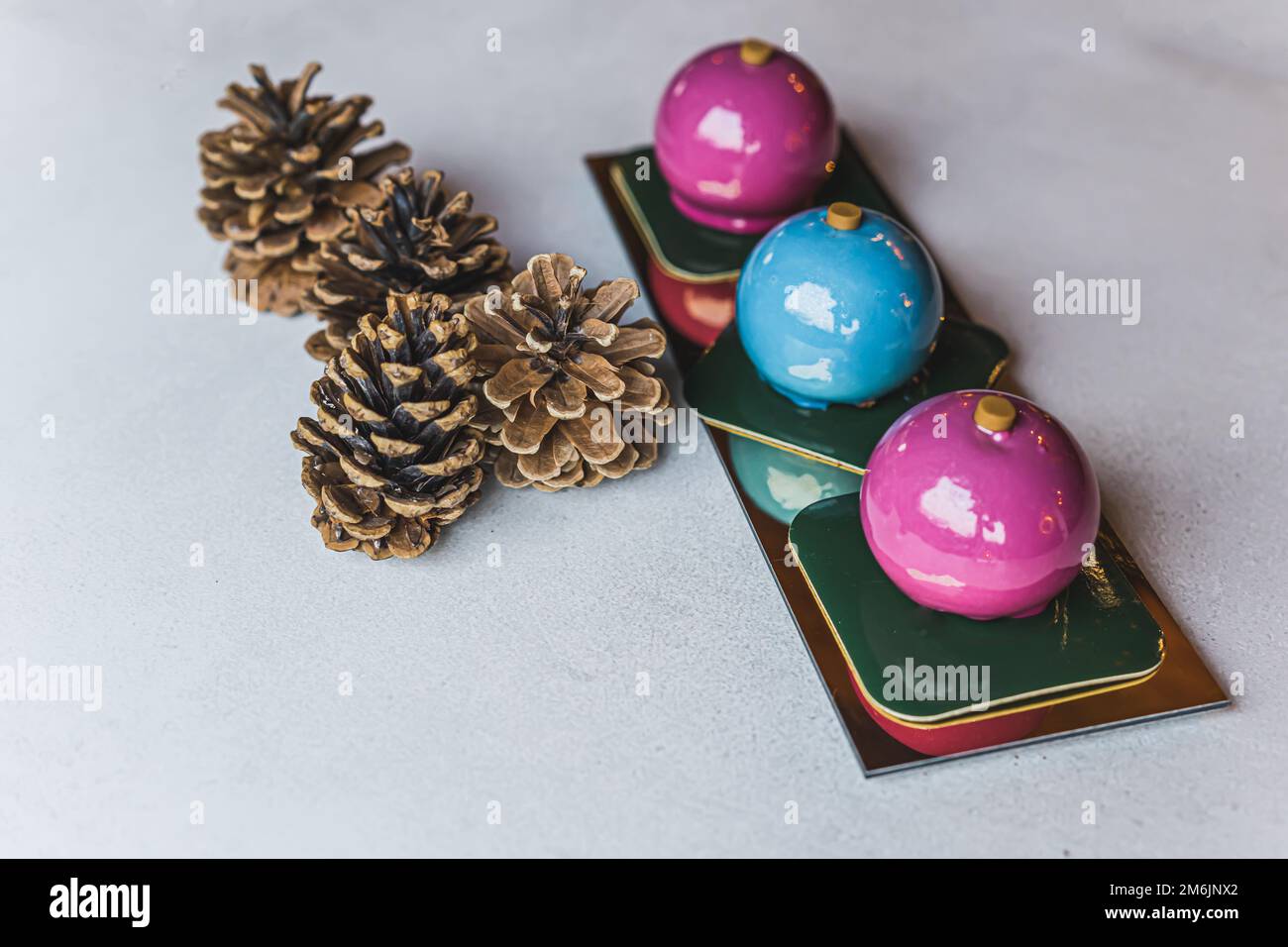 Front view of two pink and one blue cake placed in line on a golden ...