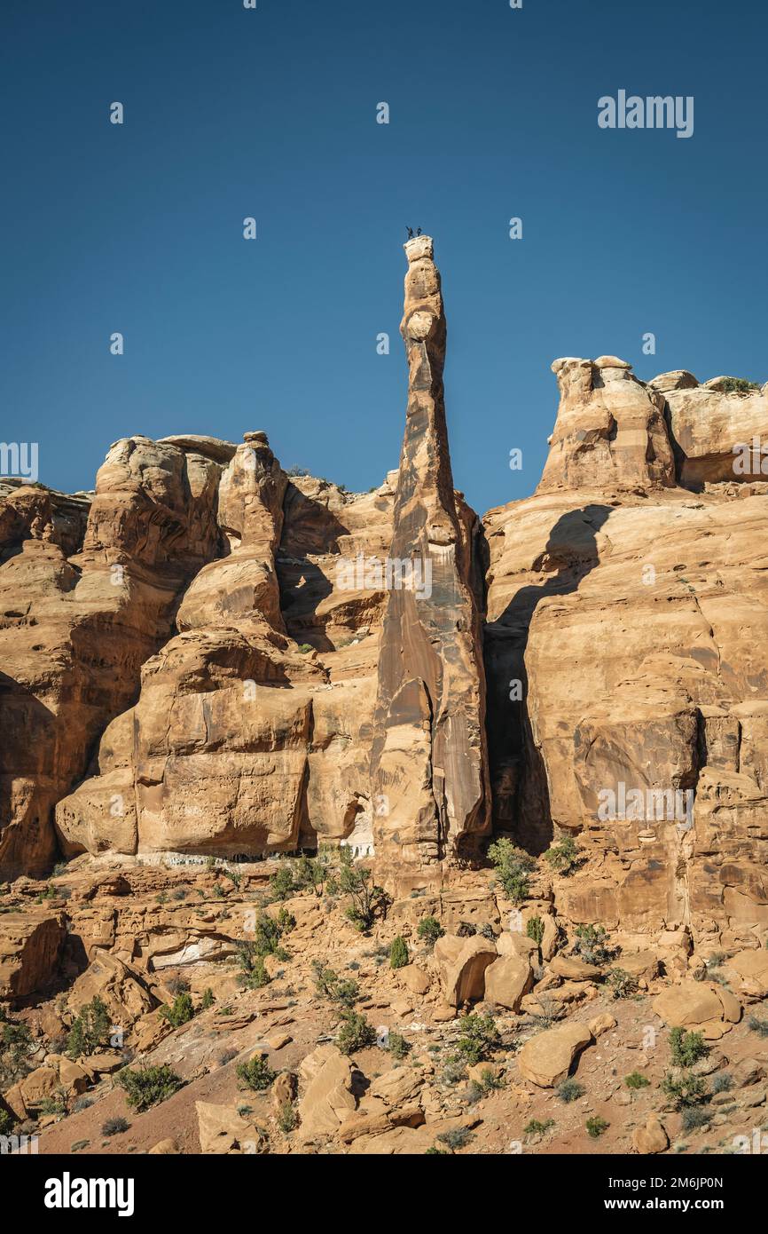 Distant shot of man and woman on rock tower Stock Photo - Alamy