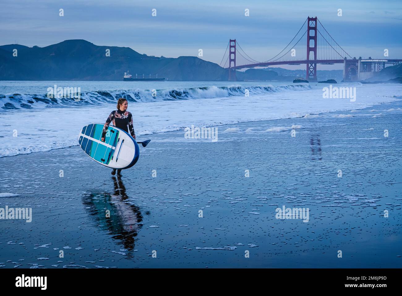 Woman carrying paddleboard hi-res stock photography and images - Alamy